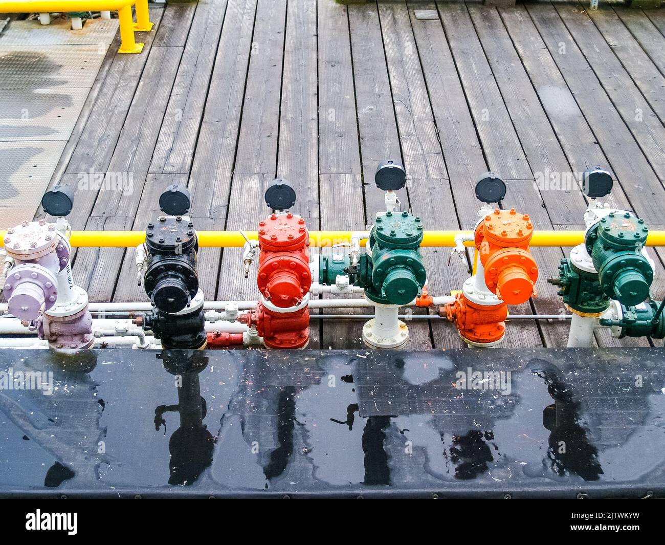 Flow valves in different colors in line on wharf Stock Photo - Alamy