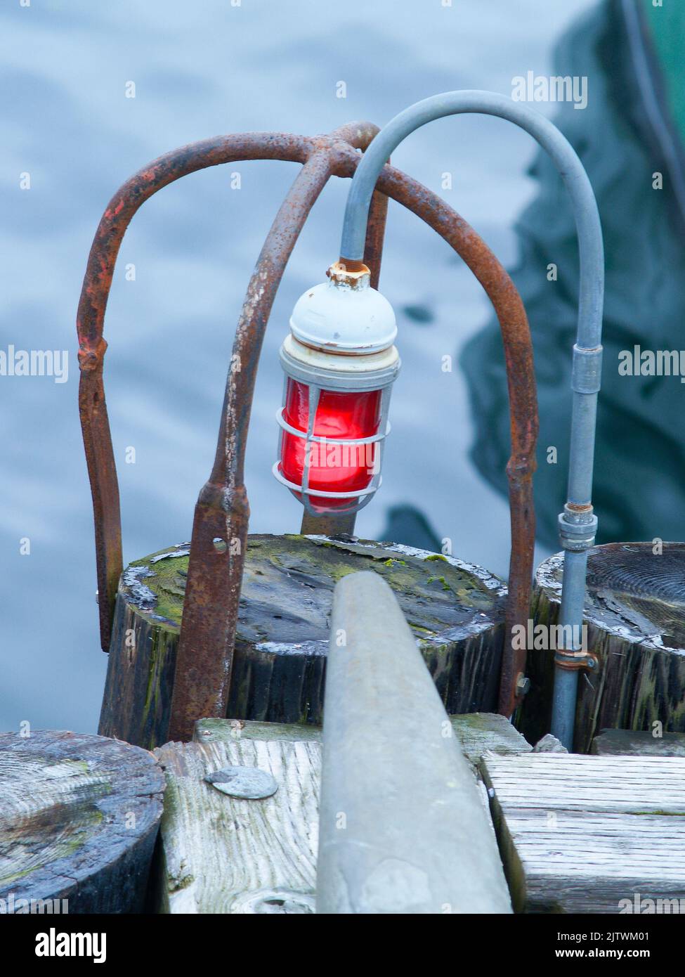 Red navigation light mounted on wharf pile showing entry direction ...