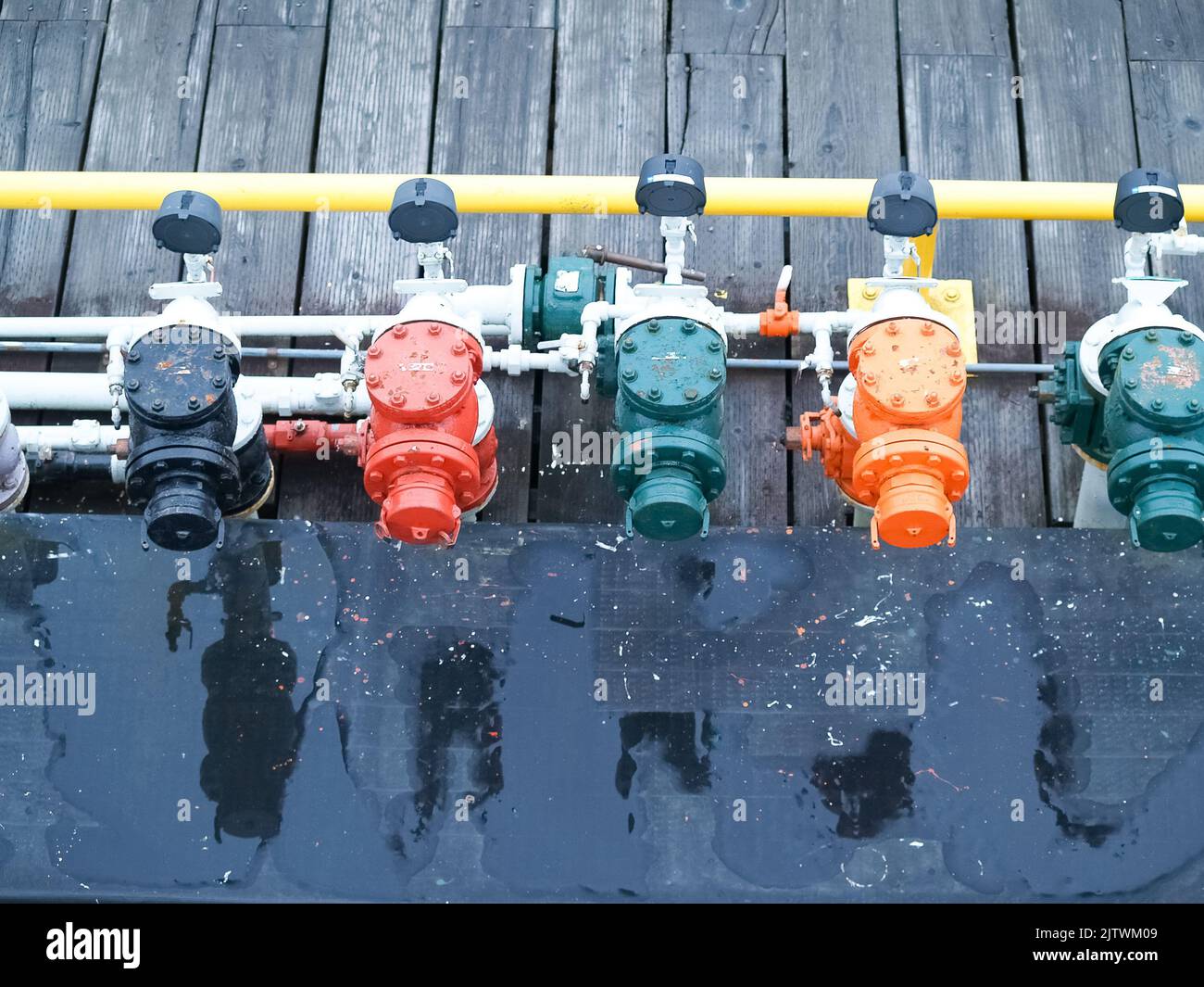 Industrial Flow valves in different colors in line on wharf Stock Photo ...