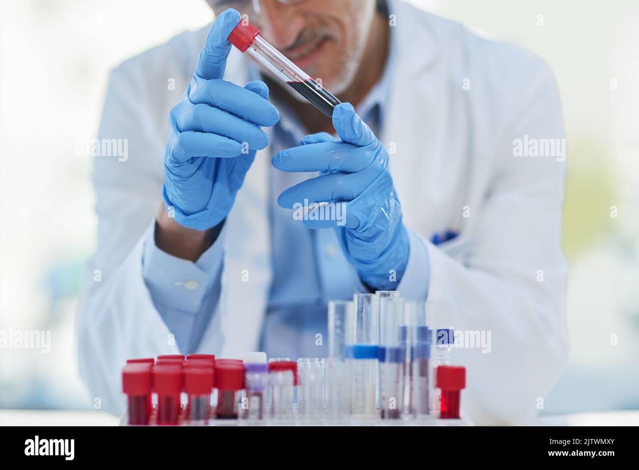 Discovering solutions is what he does best. a male scientist examining ...