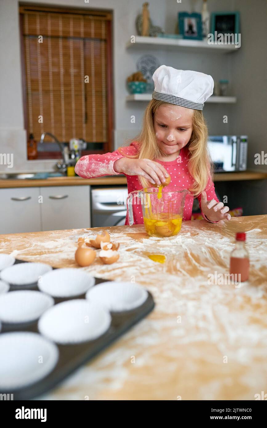 MAstering the basics of baking. a little girl baking in the kitchen ...