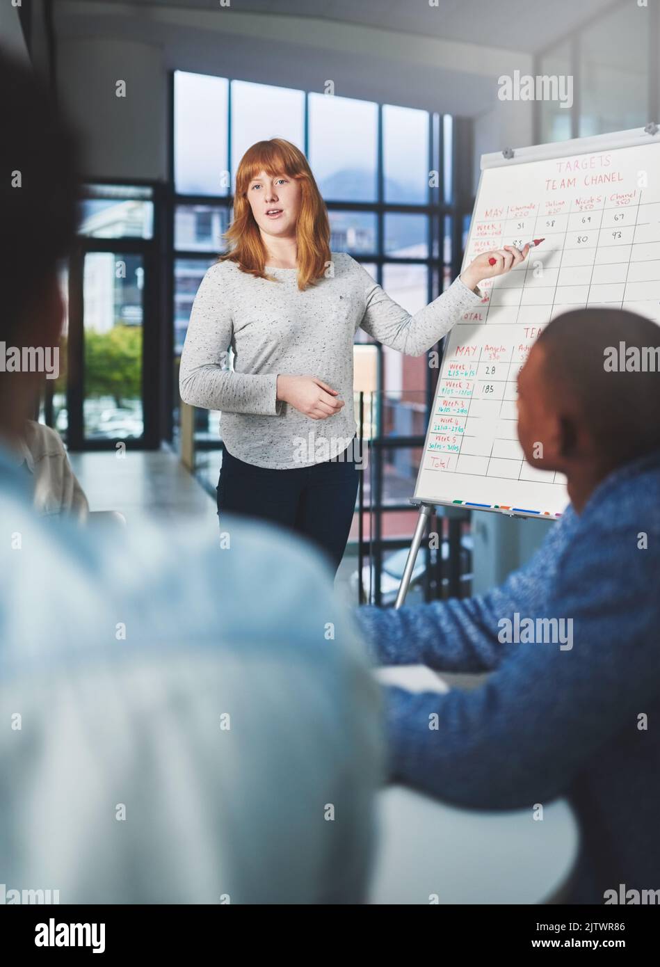 To answer your question...a young businesswoman using a whiteboard to ...