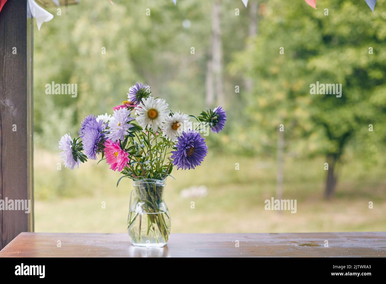 A bouquet of wild flowers on the windowsill in a vase. Front view Stock ...