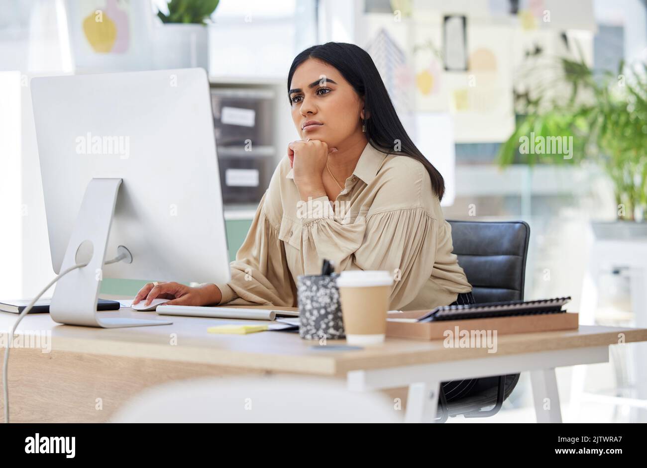 Thinking, attention and business woman on computer working by desk in ...