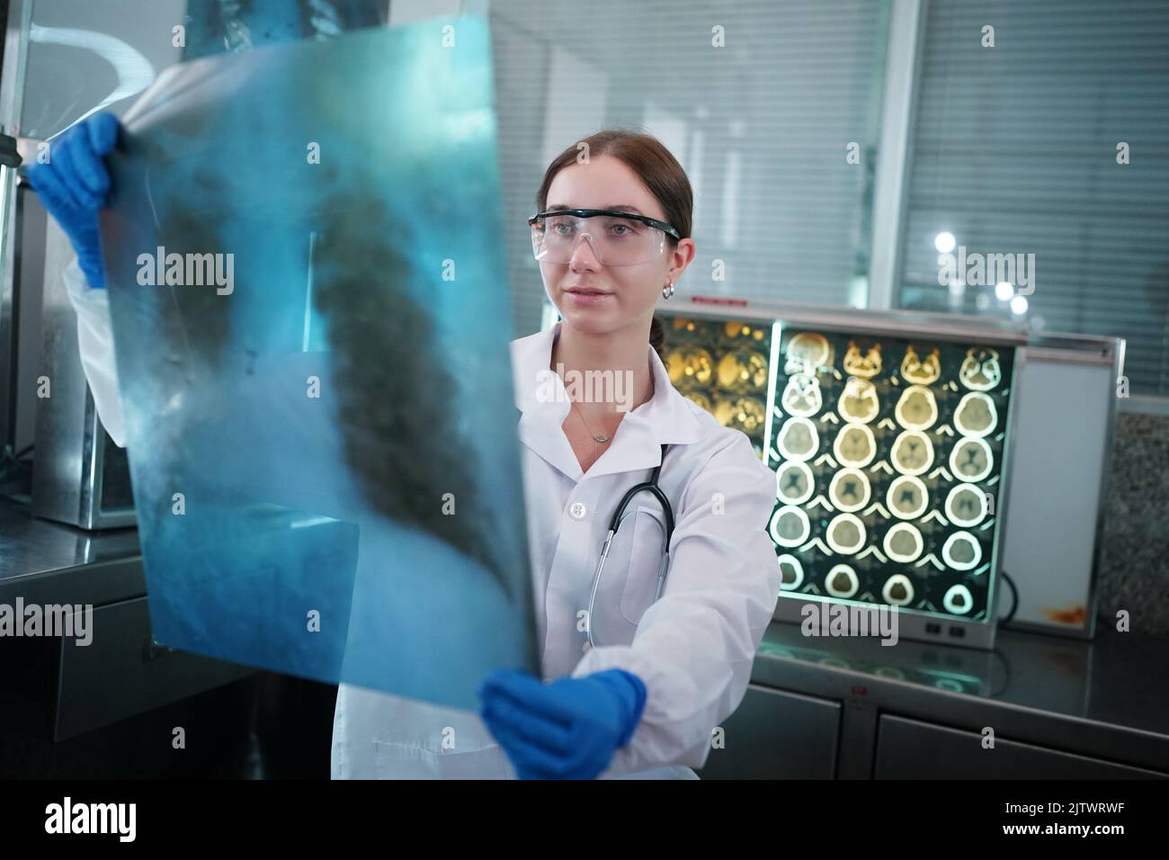 Team of doctors discuss results of X-Ray or MRI scan of patient's brain ...