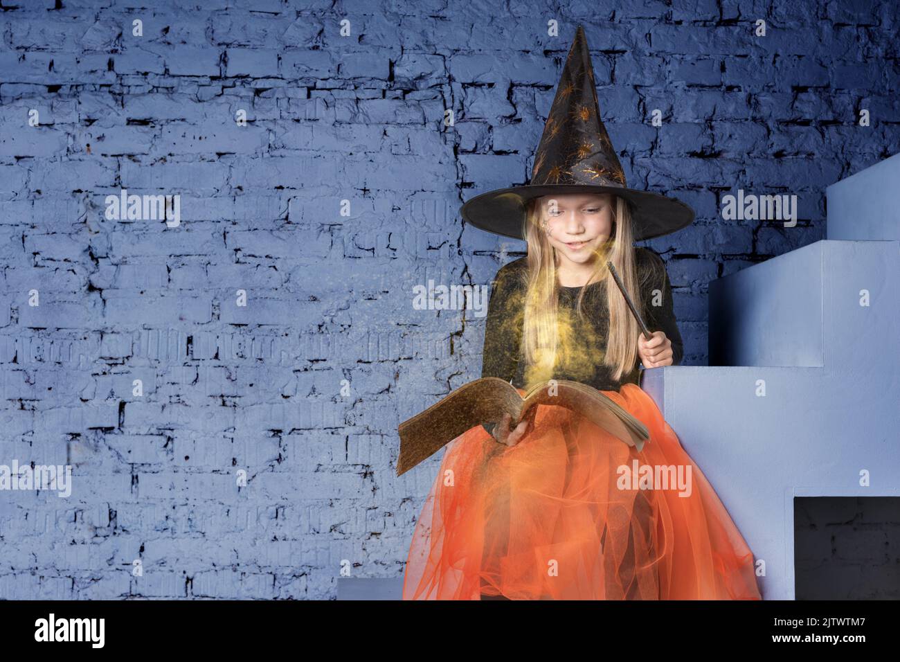 Kids Halloween. A beautiful sweet girl in a witch costume, wearing a ...