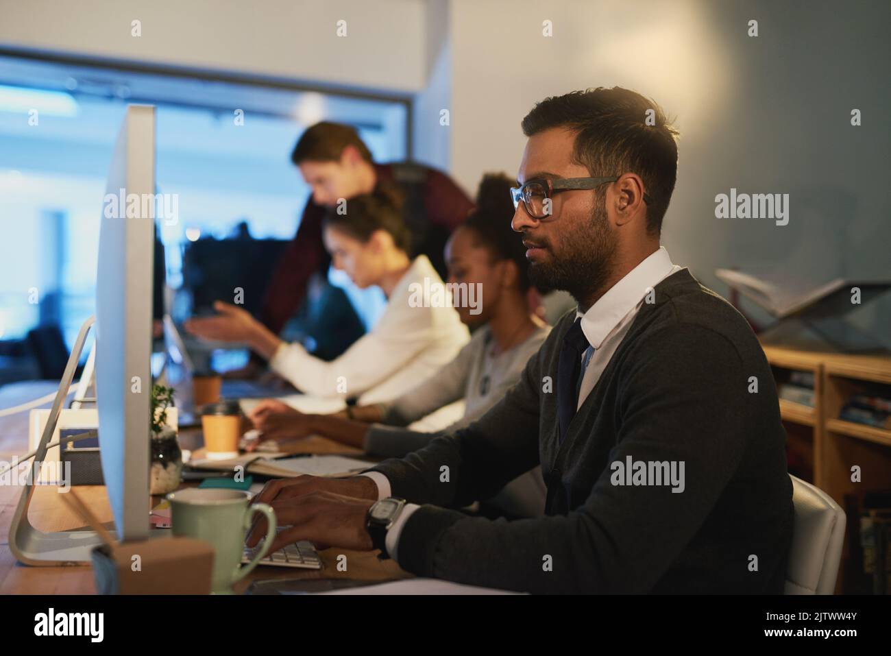Burning the midnight oil. a young businessman and his colleagues ...
