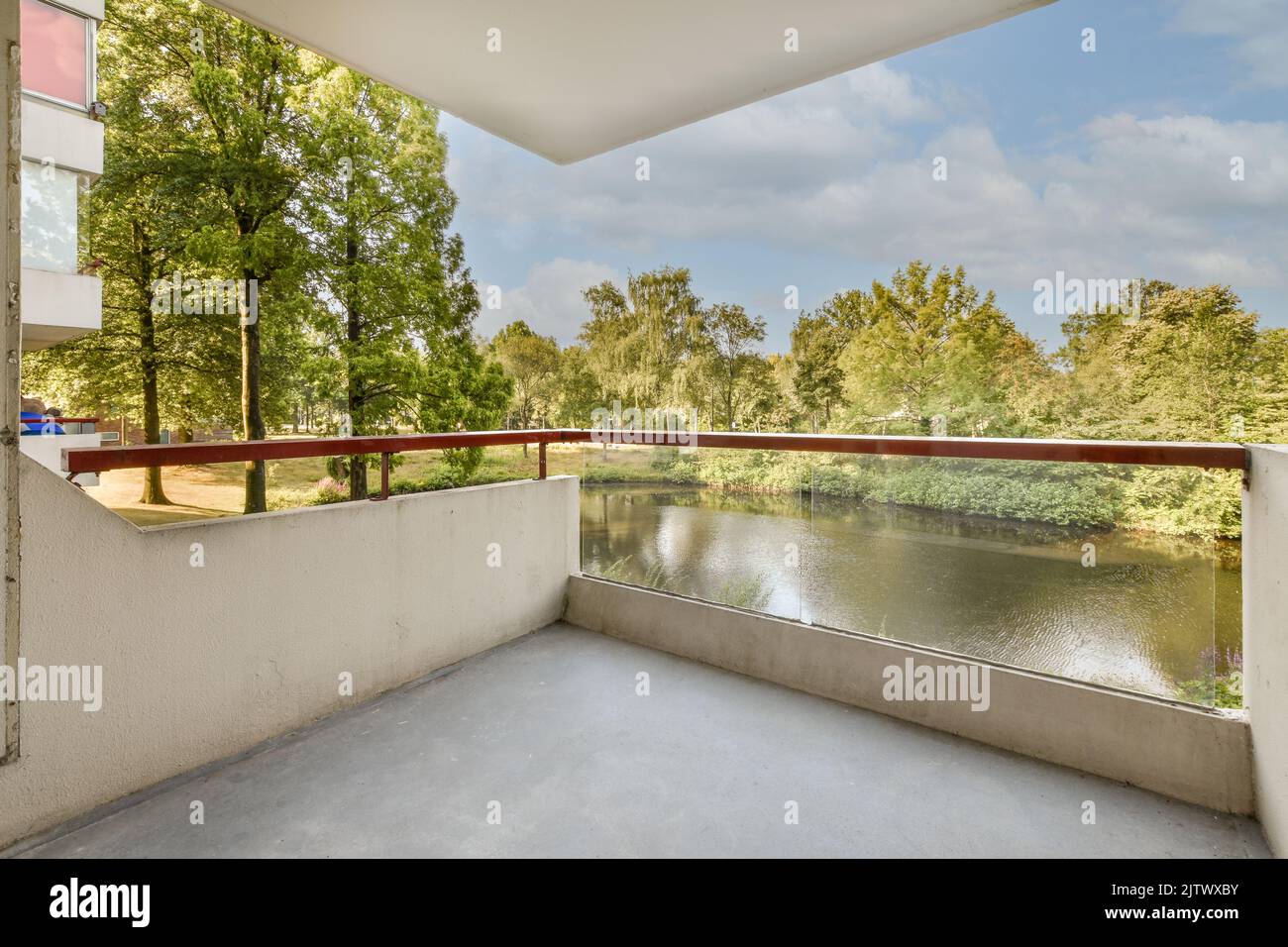 Front view of river and trees from small balcony with glass partition ...