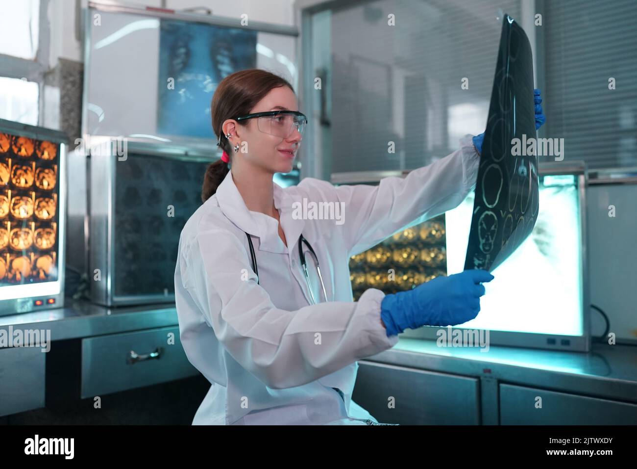 Team of doctors discuss results of X-Ray or MRI scan of patient's brain ...