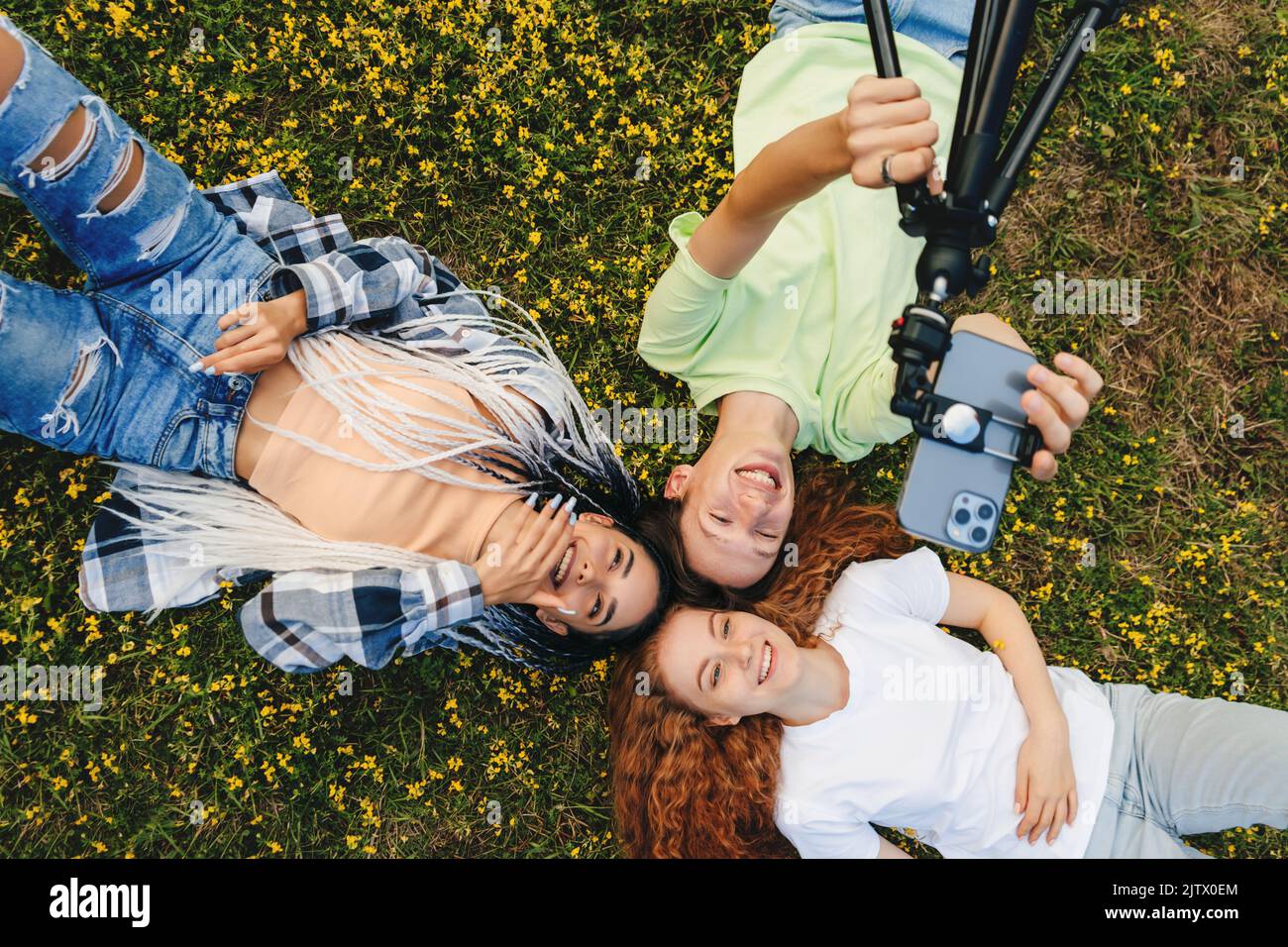 Top view group of friends enjoying time together holding phone and ...