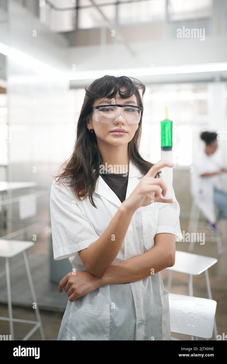 Young scientist in white lab coat working with binocular microscope in ...