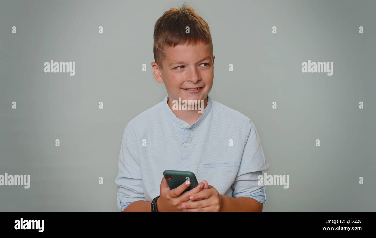 Handsome teen toddler boy texting share messages content on smartphone ...