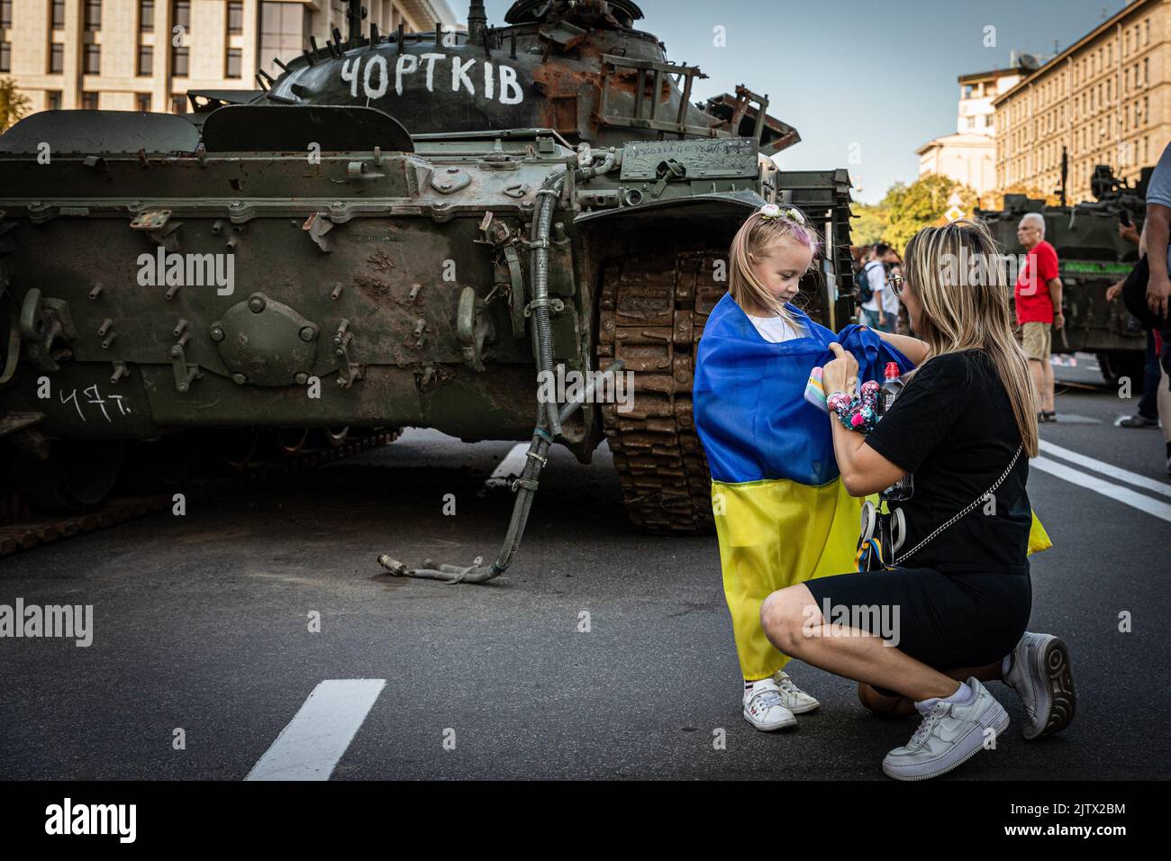A mother ties a Ukrainian flag to her daughter Sophia in front of the ...