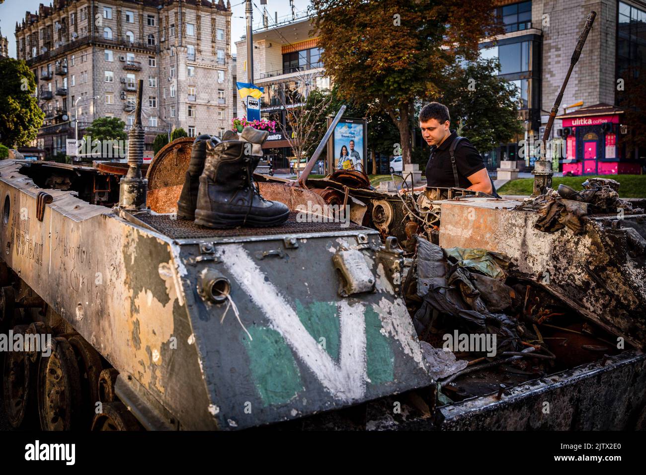 Man observes the interior of a demolished Russian military vehicle in ...