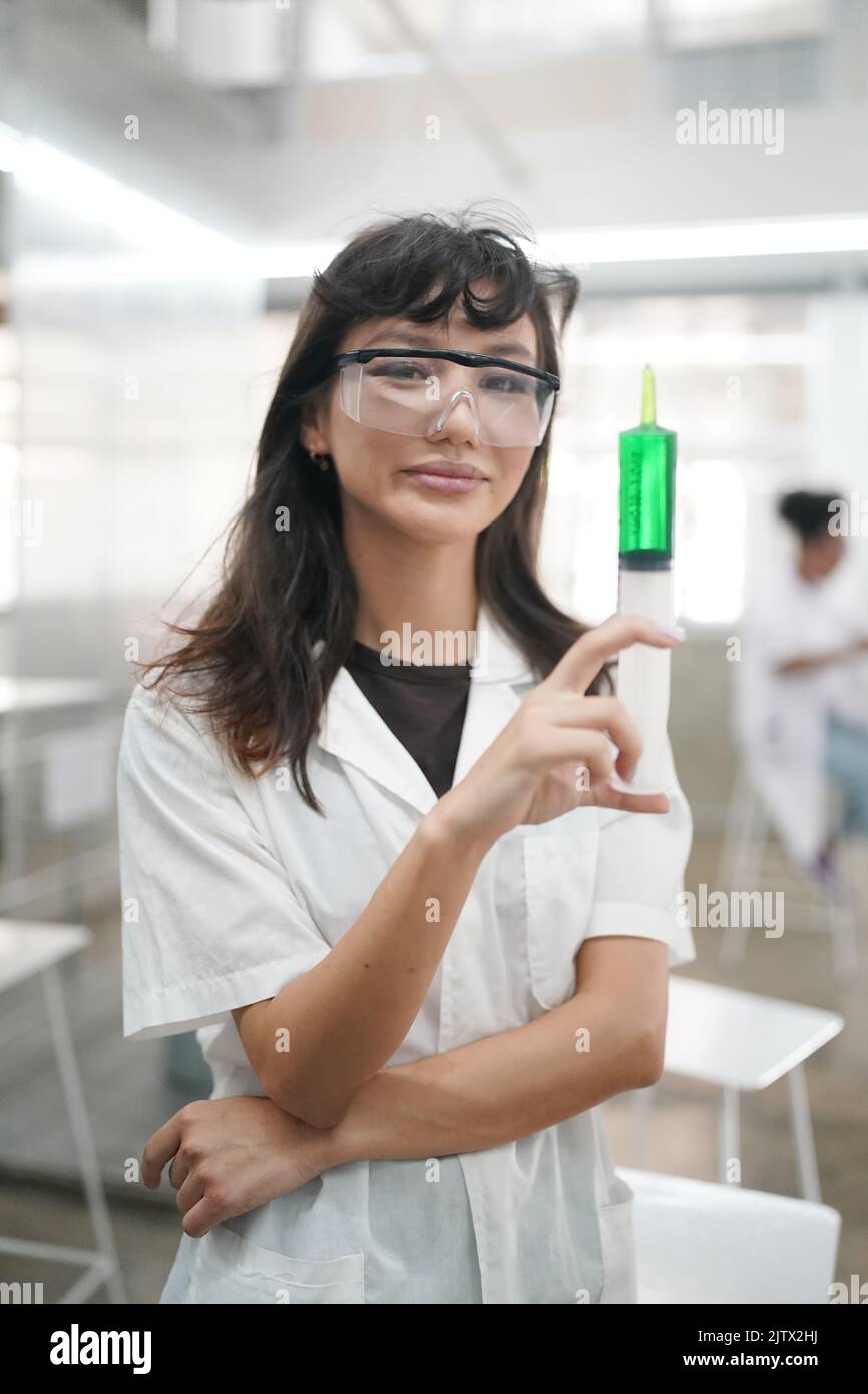Young scientist in white lab coat working with binocular microscope in ...