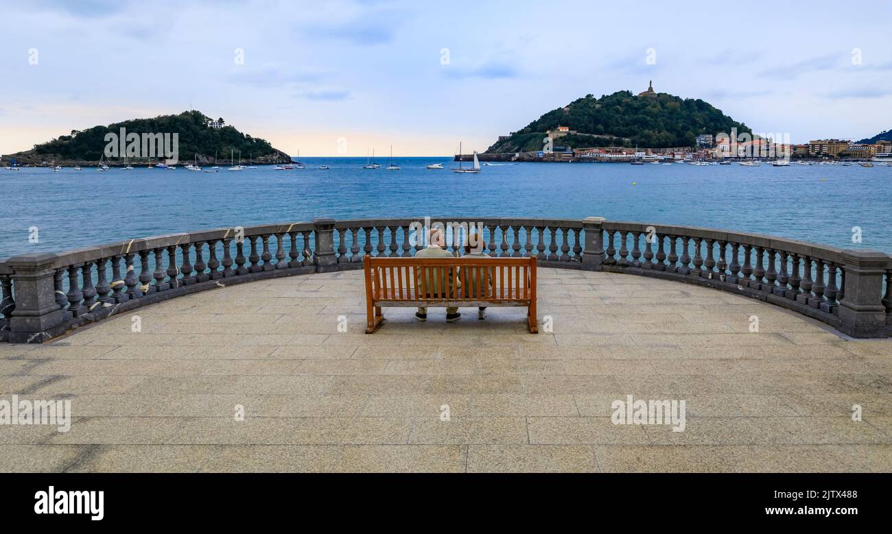 Unidentified couple on a Paseo de la Concha promenade bench with a view ...