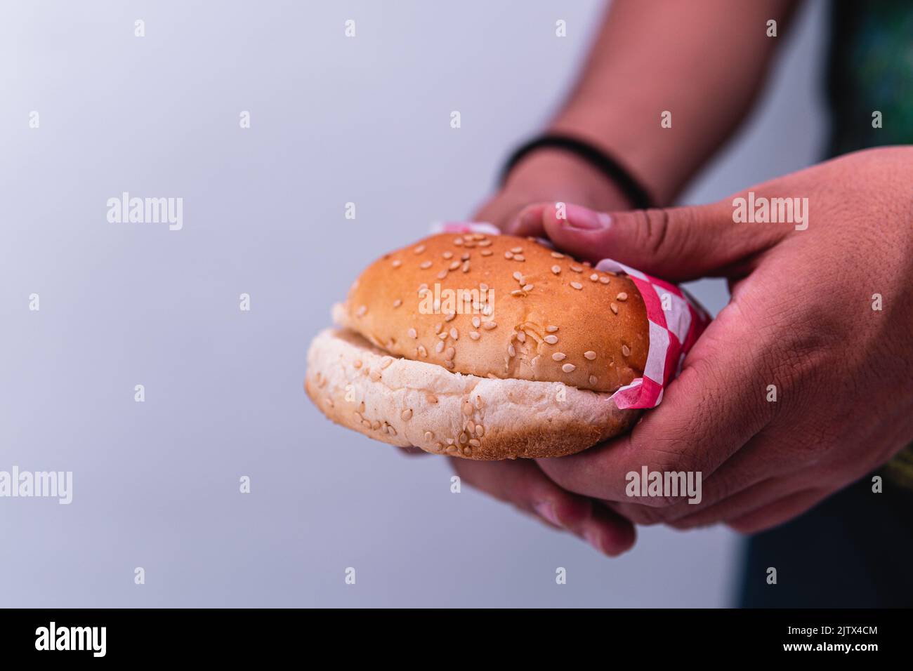 Two hamburger buns on an isolated white background. Hands holding a ...