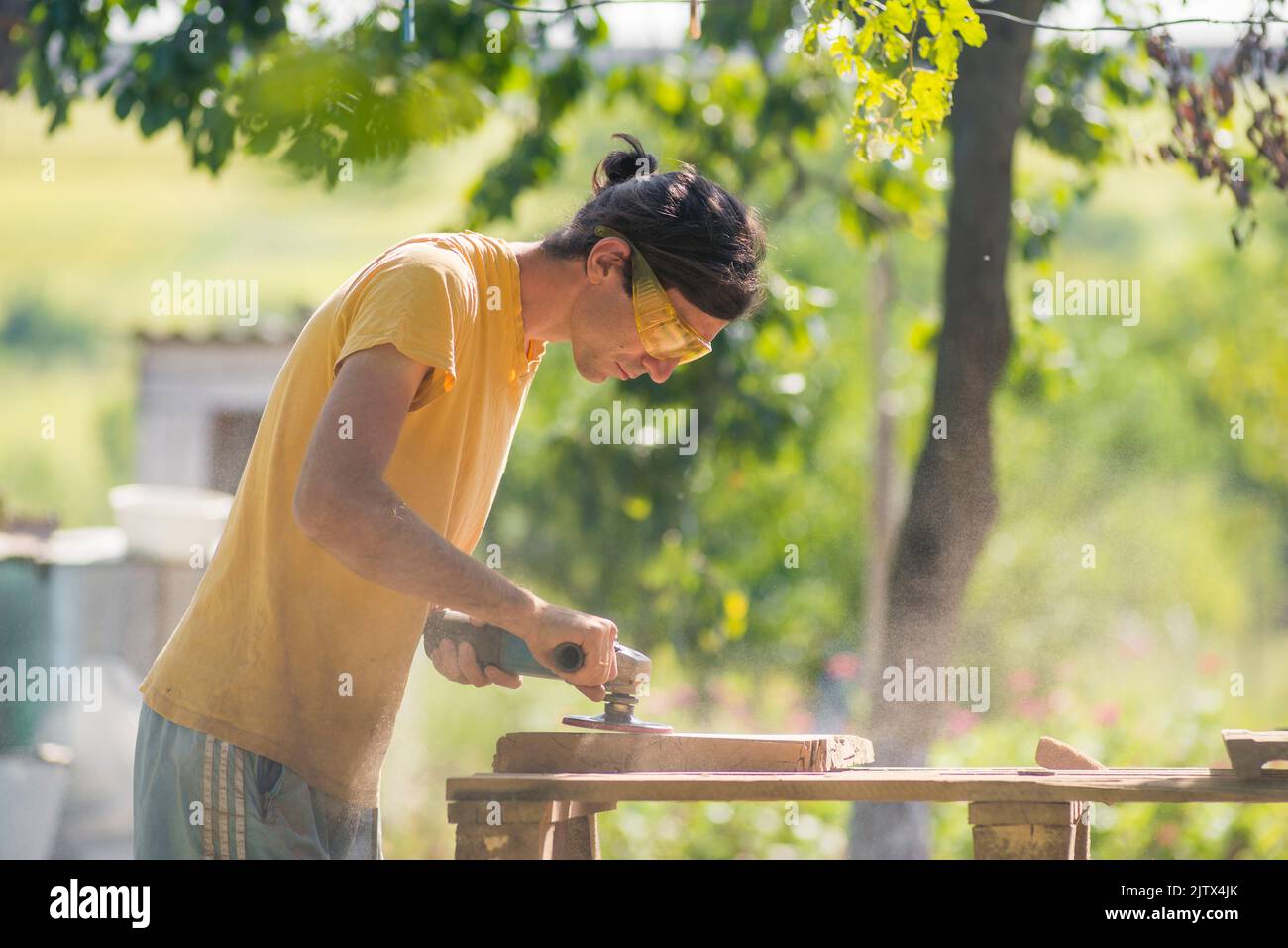 Close up of sanding a wood with orbital sander at workshop electric ...