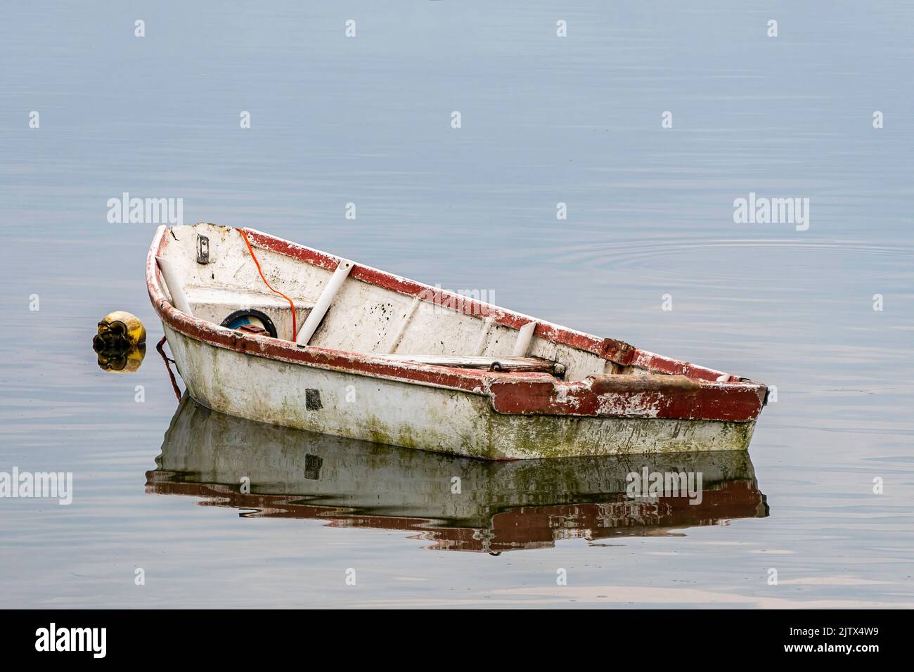 Reflection in the water of fishing boats standing on the pier in the ...