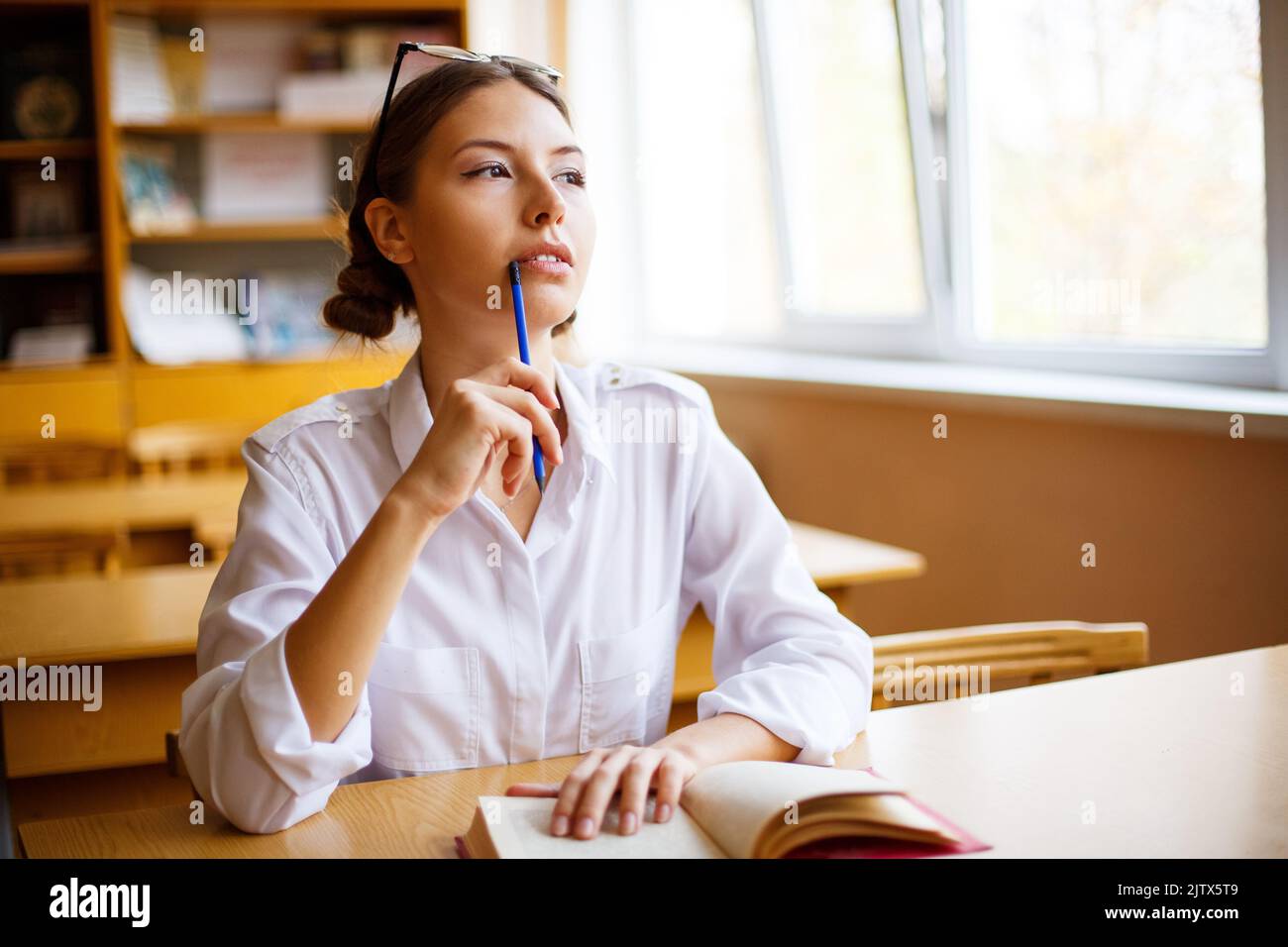 Focused millennial female student sits in classroom studying with ...