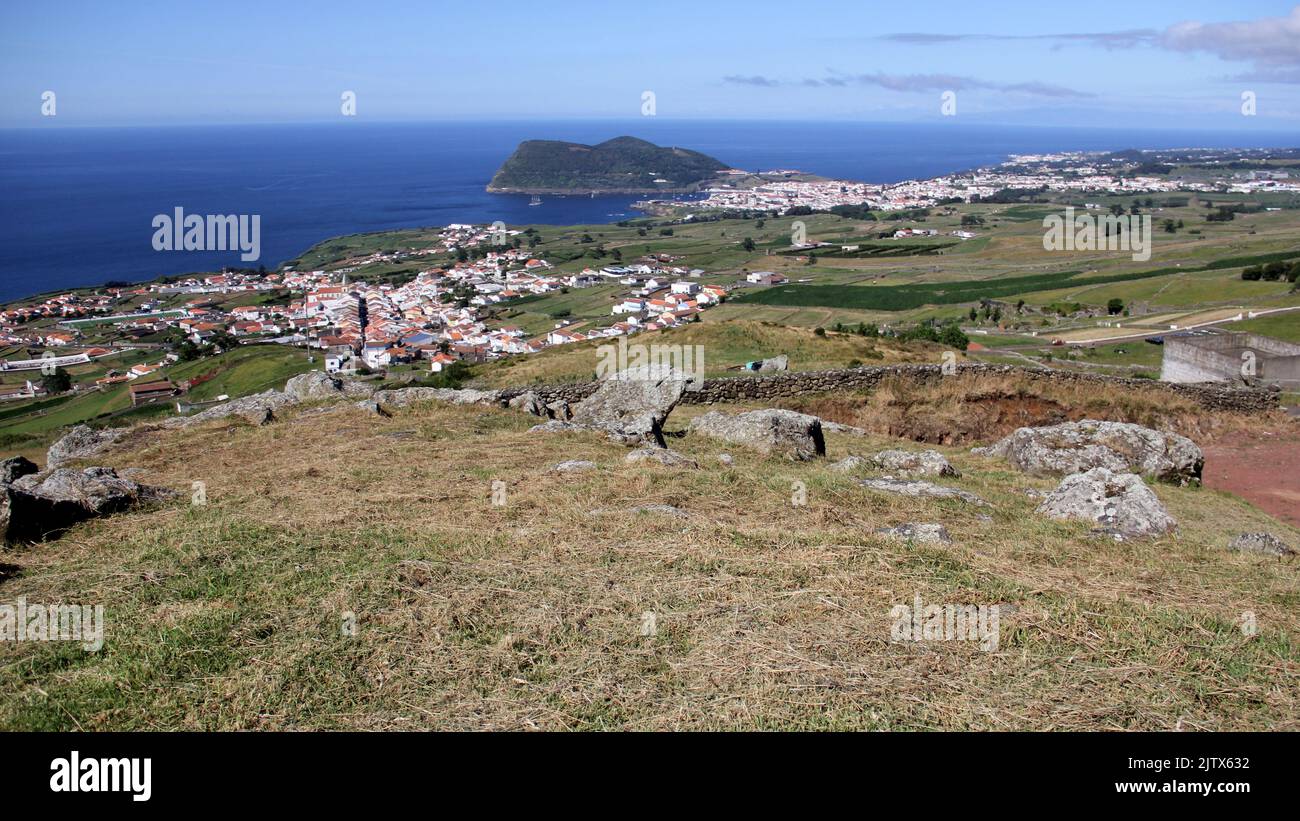 Rural landscape, with green pastures and stone fences, sloping toward ...