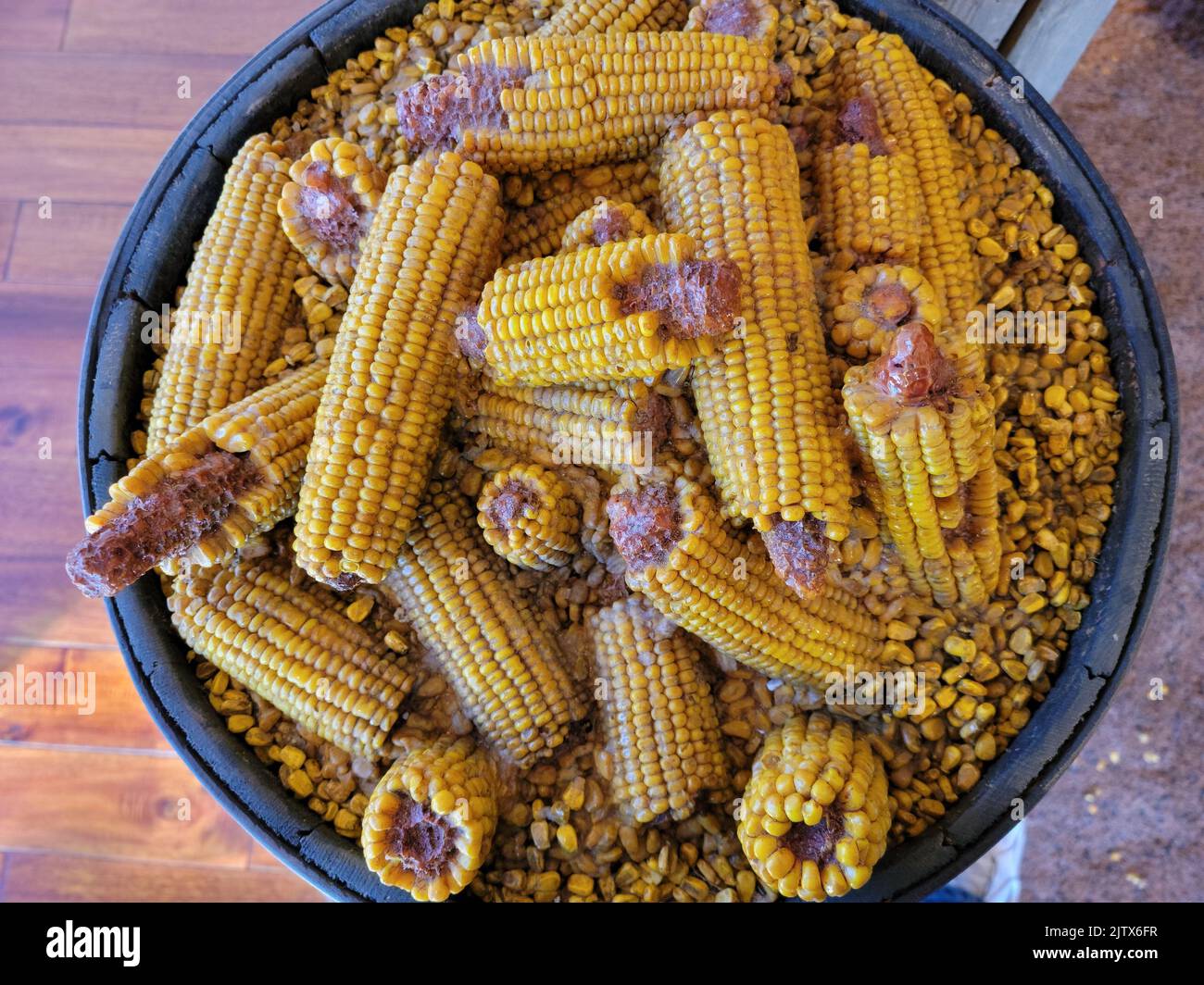 large barrel or container of yellow corn kernels on wood floor Stock ...
