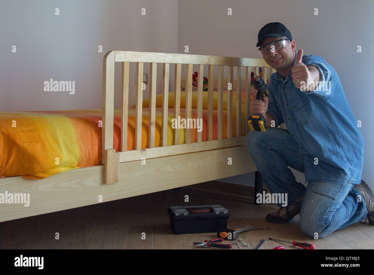 Smiling man with screwdriver and work tools after having finished ...