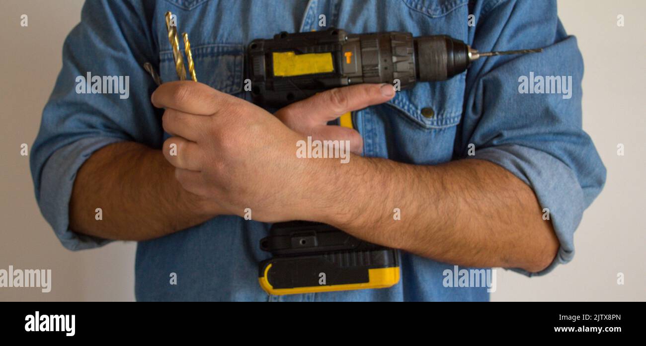 Handyman man holding a screwdriver and drill bits. Craft projects at ...