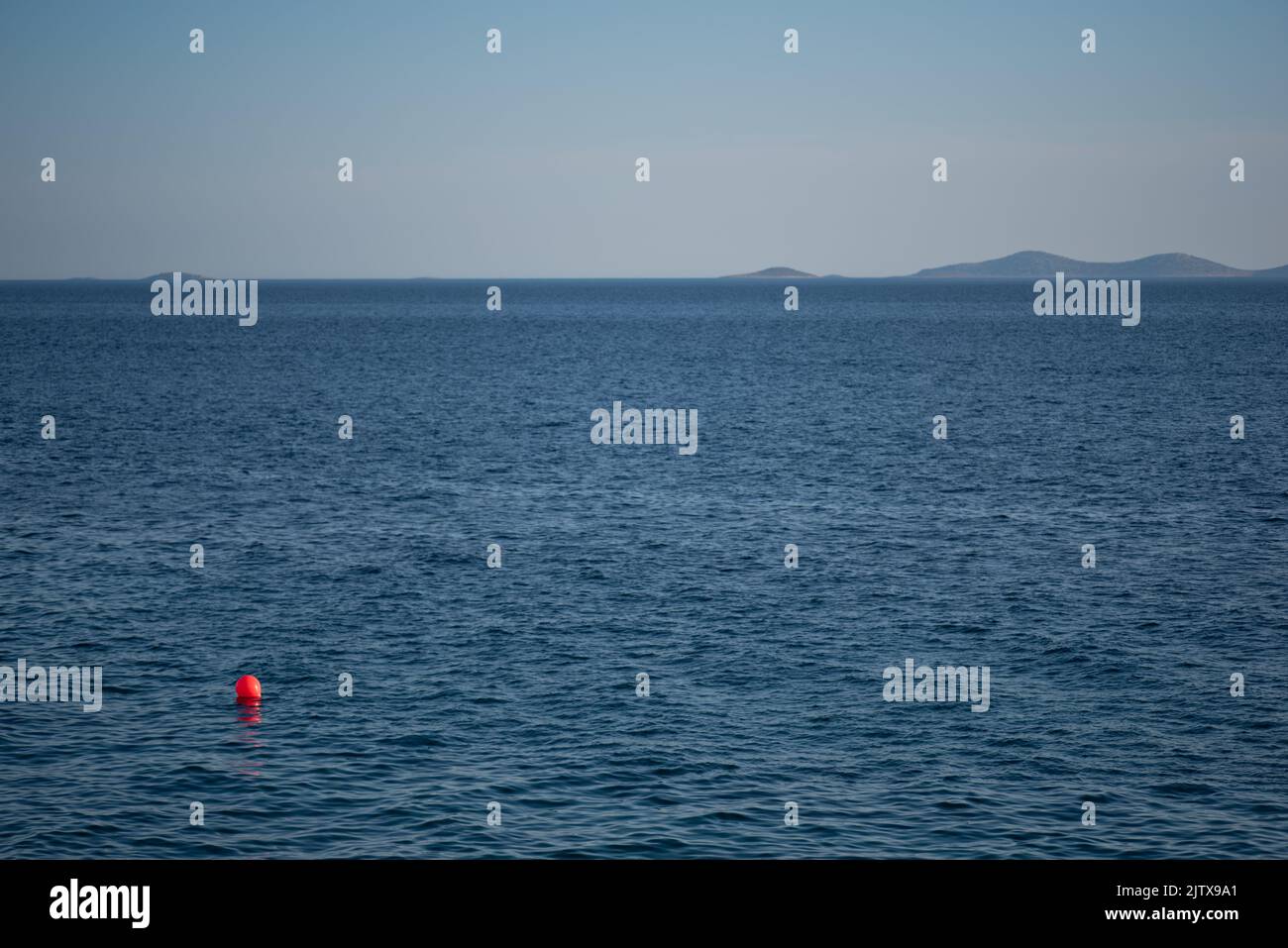 An orange round buoy floating on the sea Stock Photo - Alamy