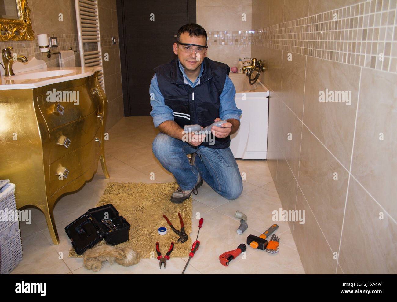 Handyman man struggling with a repair of a bathroom plumbing Stock ...