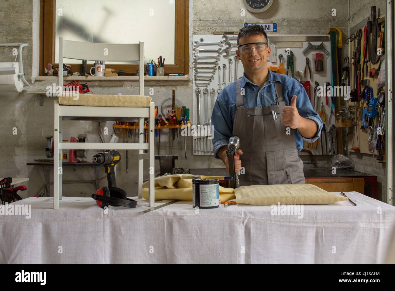 handyman at work with the restoration of old chairs in his garage ...