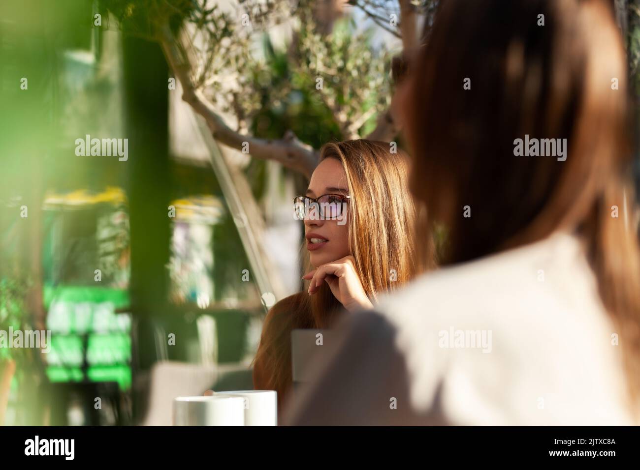 Two young business women in a cafe having one on one meeting. Friends ...