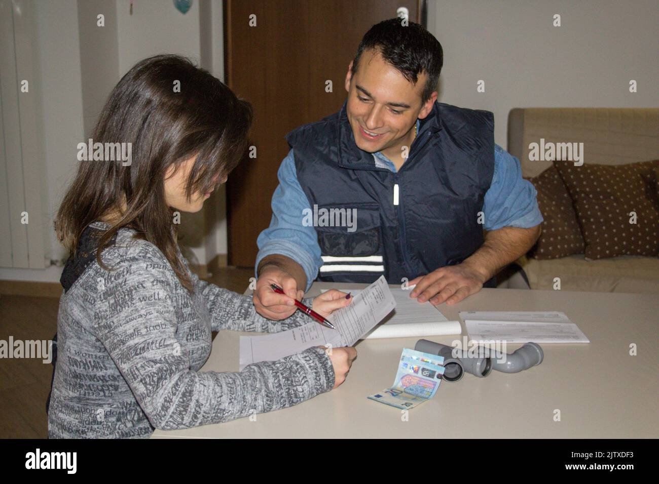 Photo of a plumber with a woman as they enter into a contract and quote ...