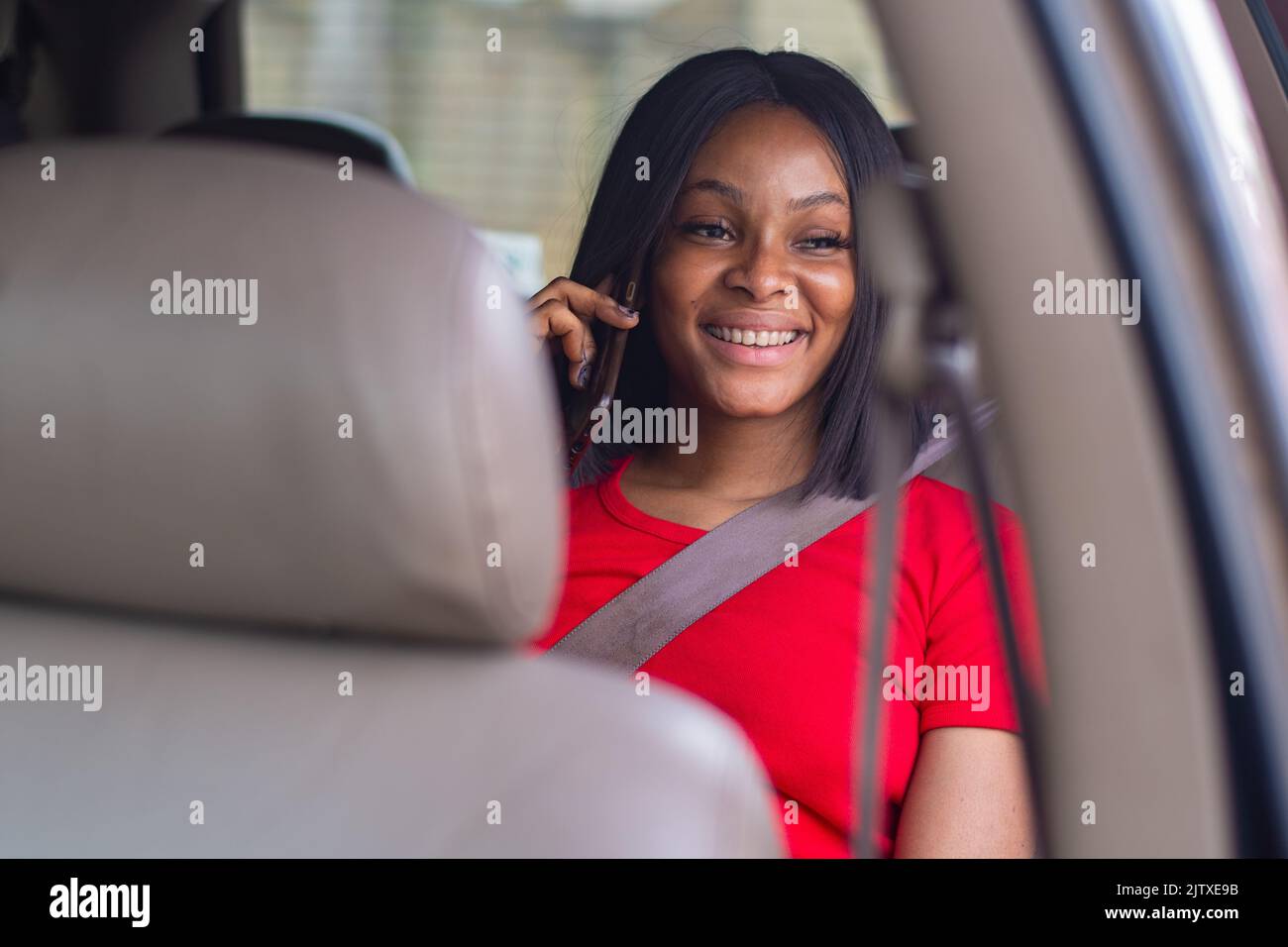 pretty african lady making a phone call in a car Stock Photo - Alamy