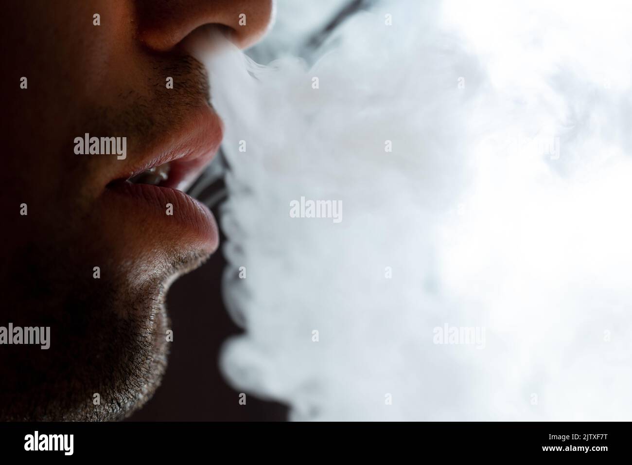 Seductive male lips blowing cigarette smoke, light stubble on beard ...