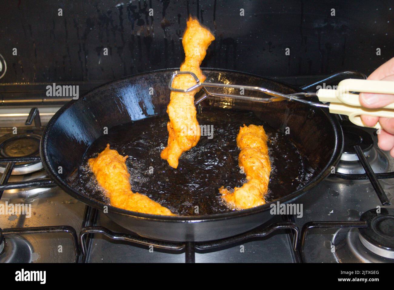 Pan on the stove with boiling oil while frying a dessert. Typical ...