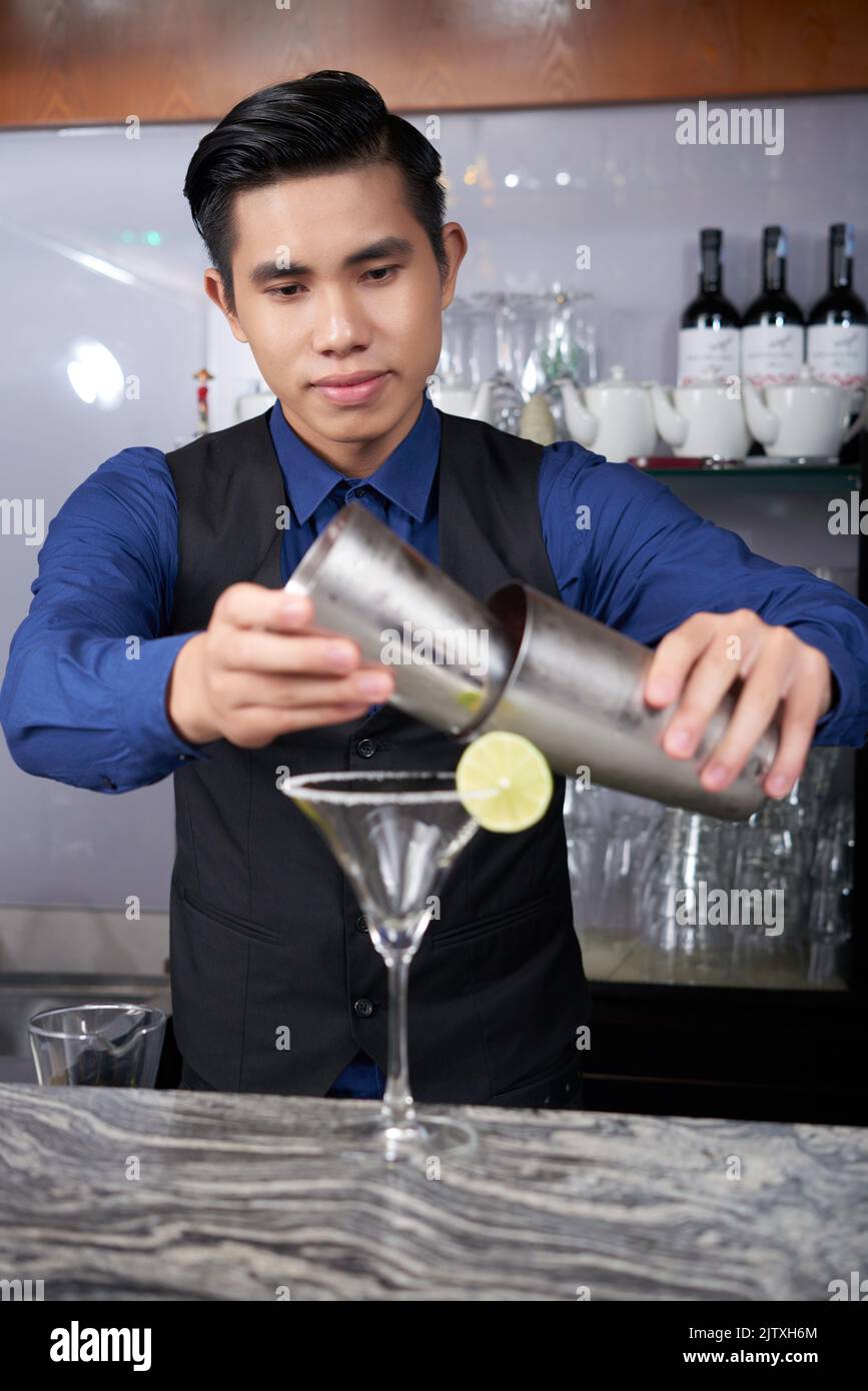 Young Vietnamese professional barman making margarita cocktail Stock ...