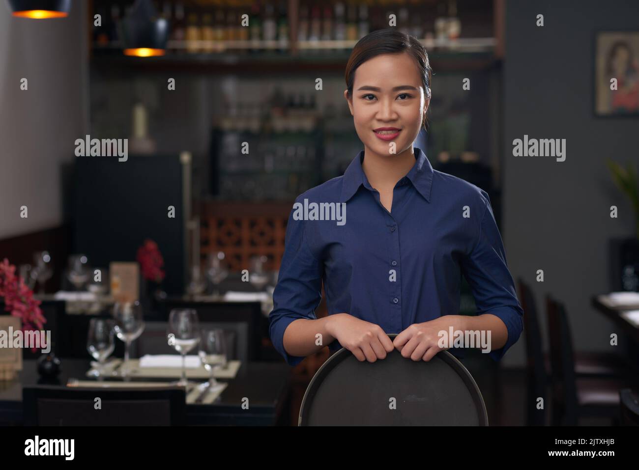 Portrait of pretty Vietnamese waitress with empty tray Stock Photo - Alamy