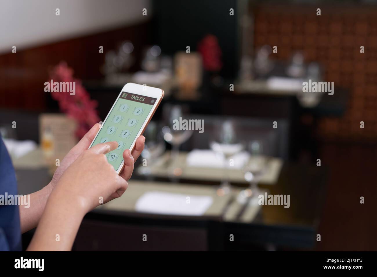 Banquet manager using mobile application to arrange tables Stock Photo ...