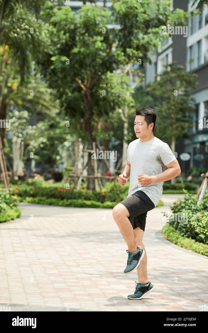 Active handsome young man running outdoors Stock Photo - Alamy