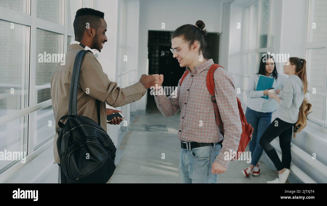 Group of students is standing in big spacious corridor girl are talking ...