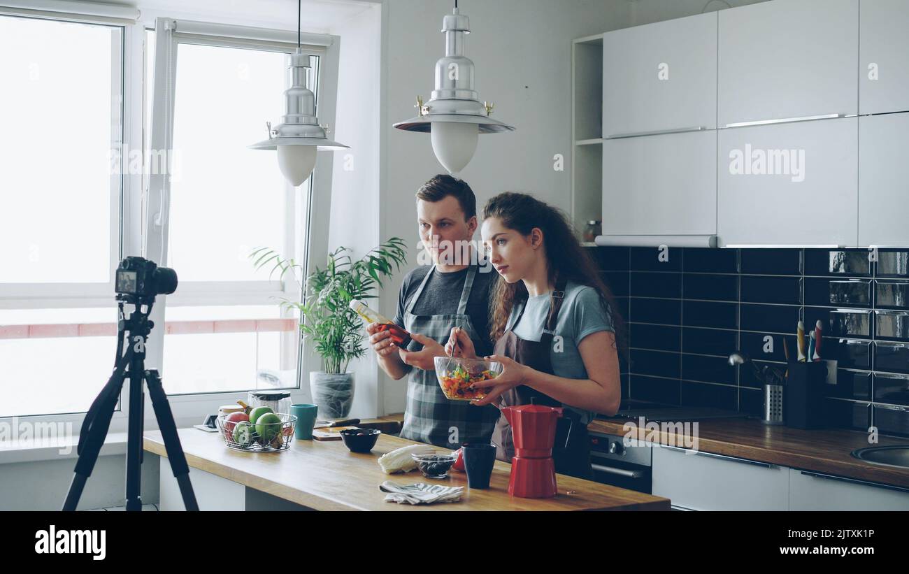Smiling attractive couple recording video food vlog about cooking ...