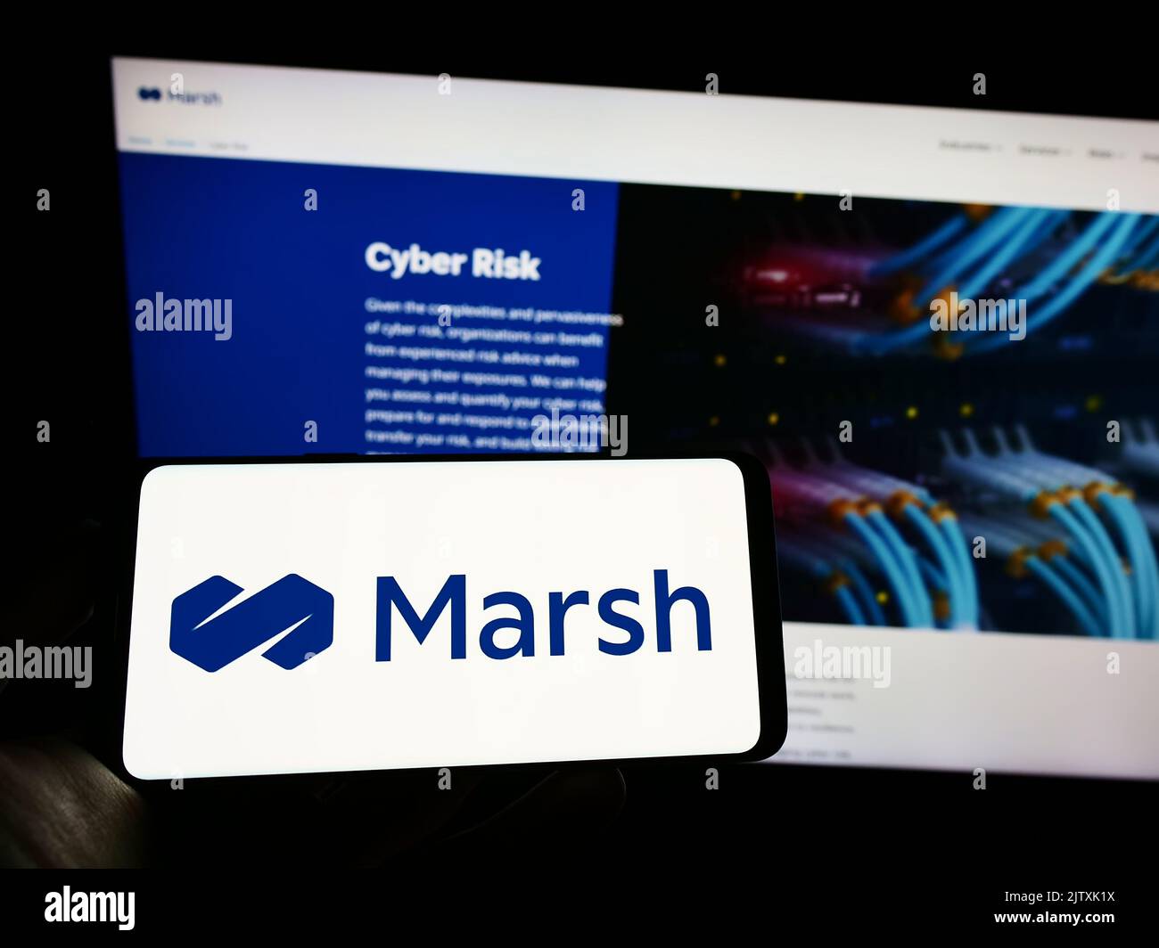Person holding cellphone with logo of US financial company Marsh Inc ...