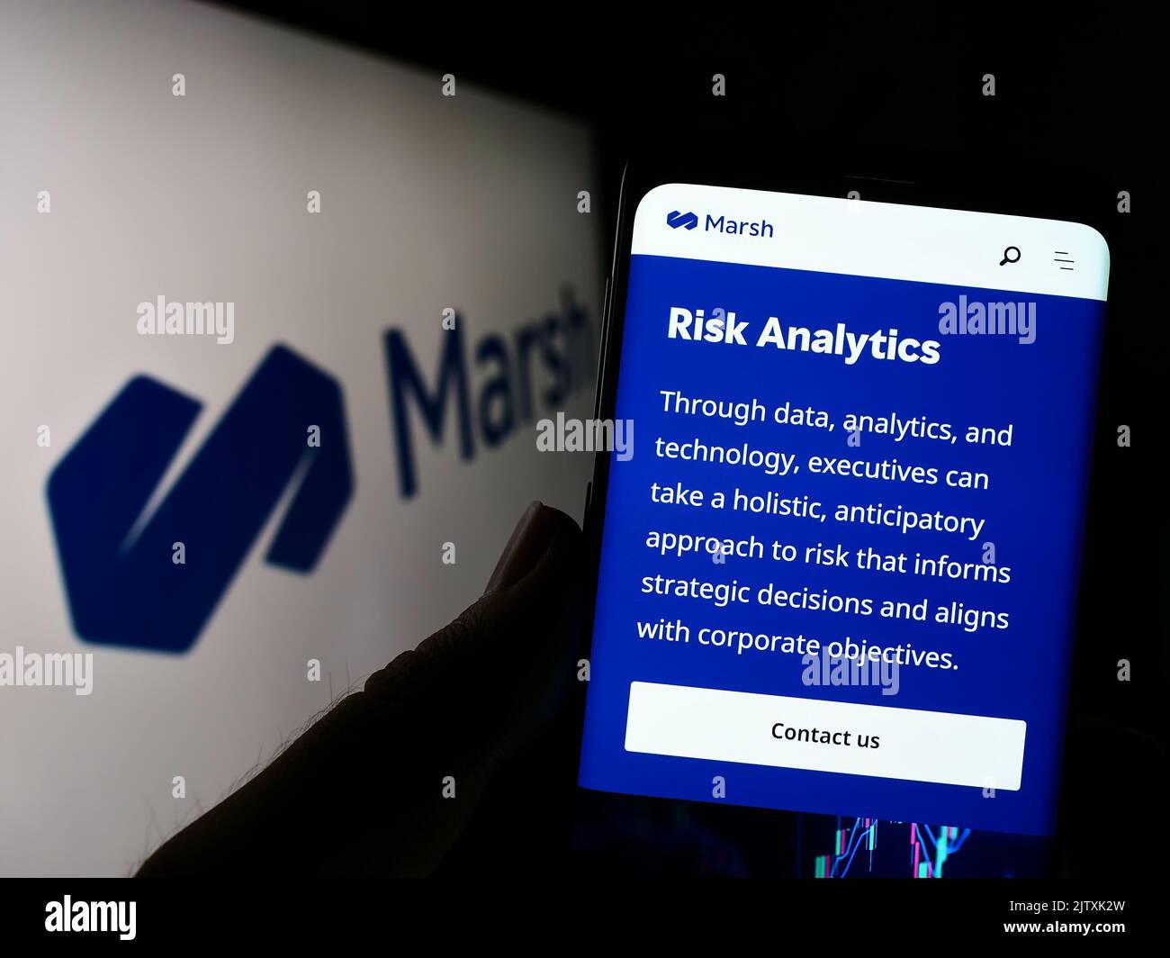 Person holding cellphone with webpage of US financial company Marsh Inc ...