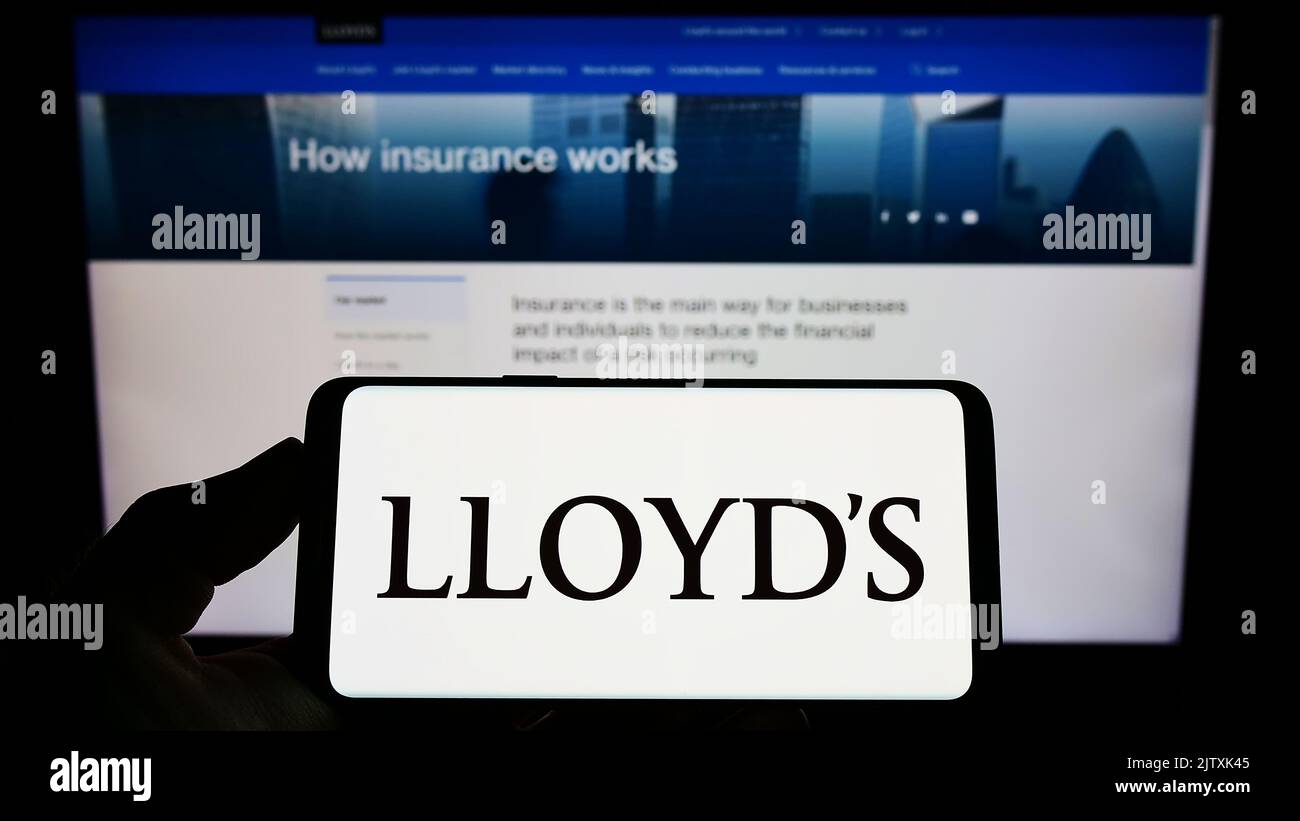 Person holding smartphone with logo of British insurance marketplace ...