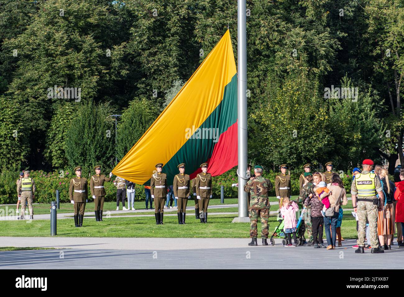 Lithuanian flag on a flag pole during a ceremony with soldiers ...