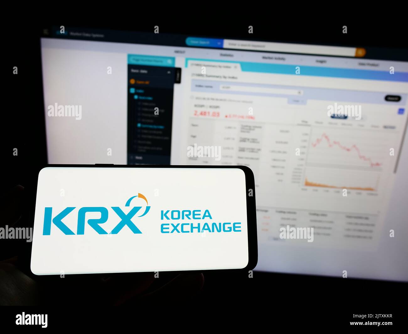 Person holding mobile phone with logo of financial marketplace Korea ...