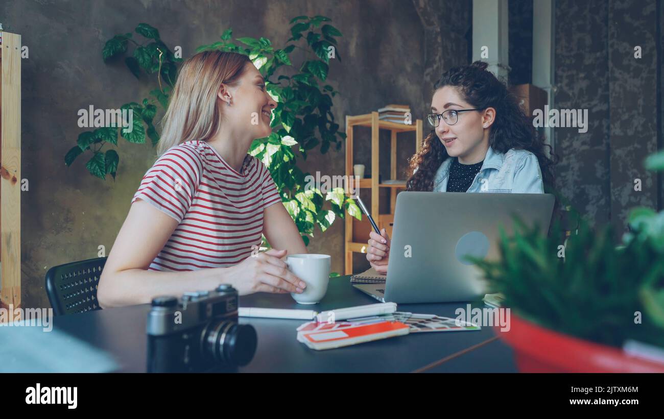 Young and pretty female students are sitting in light room together and ...