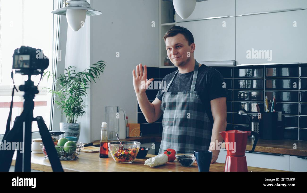 Cheerful attractive man recording video food vlog about healthy cooking ...