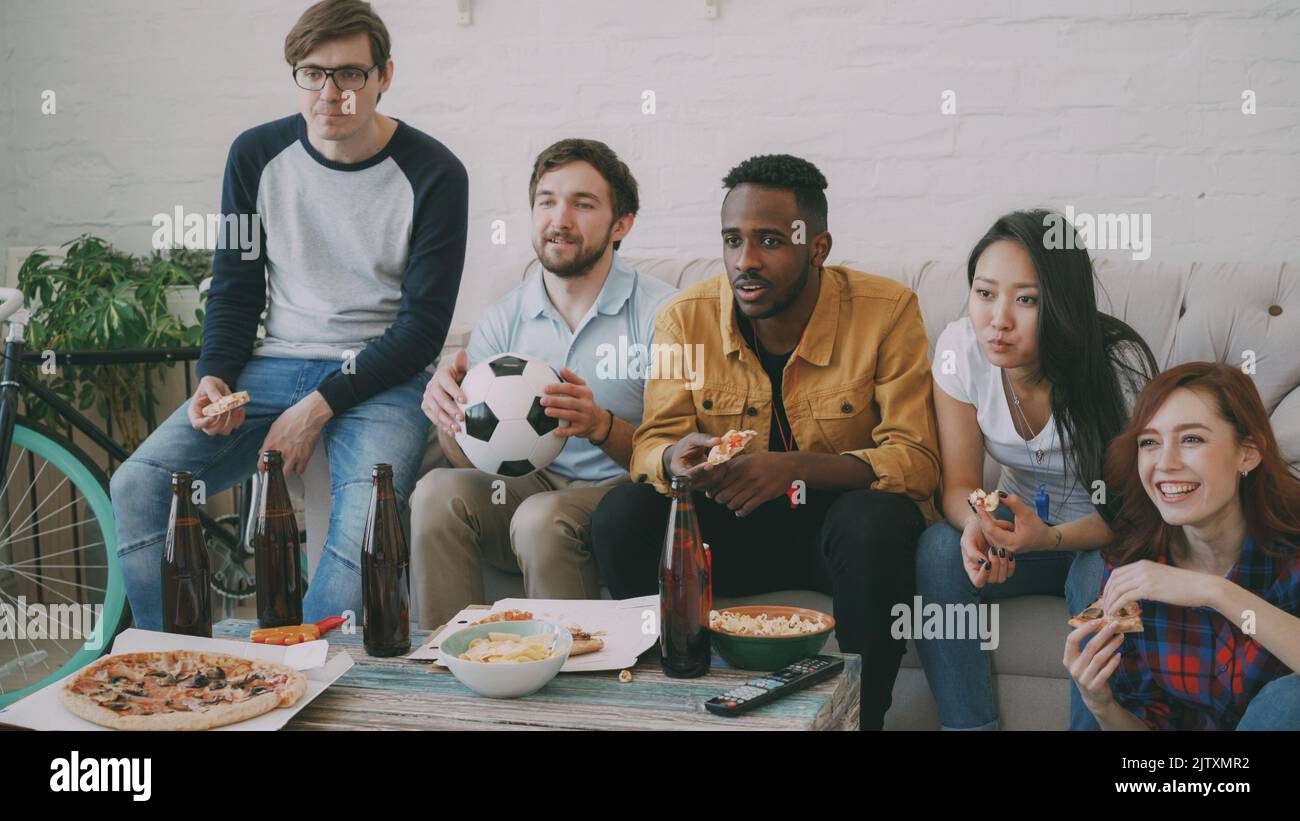 Multi ethnic group of friends sports fans watching football ...